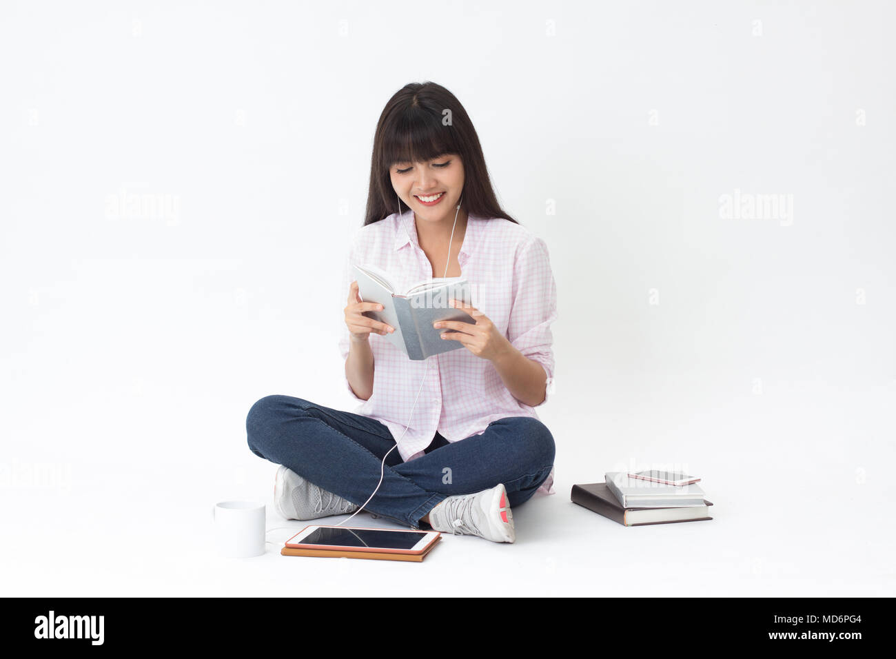 Beautiful Thai girl learning and study hard sitting on white background ...