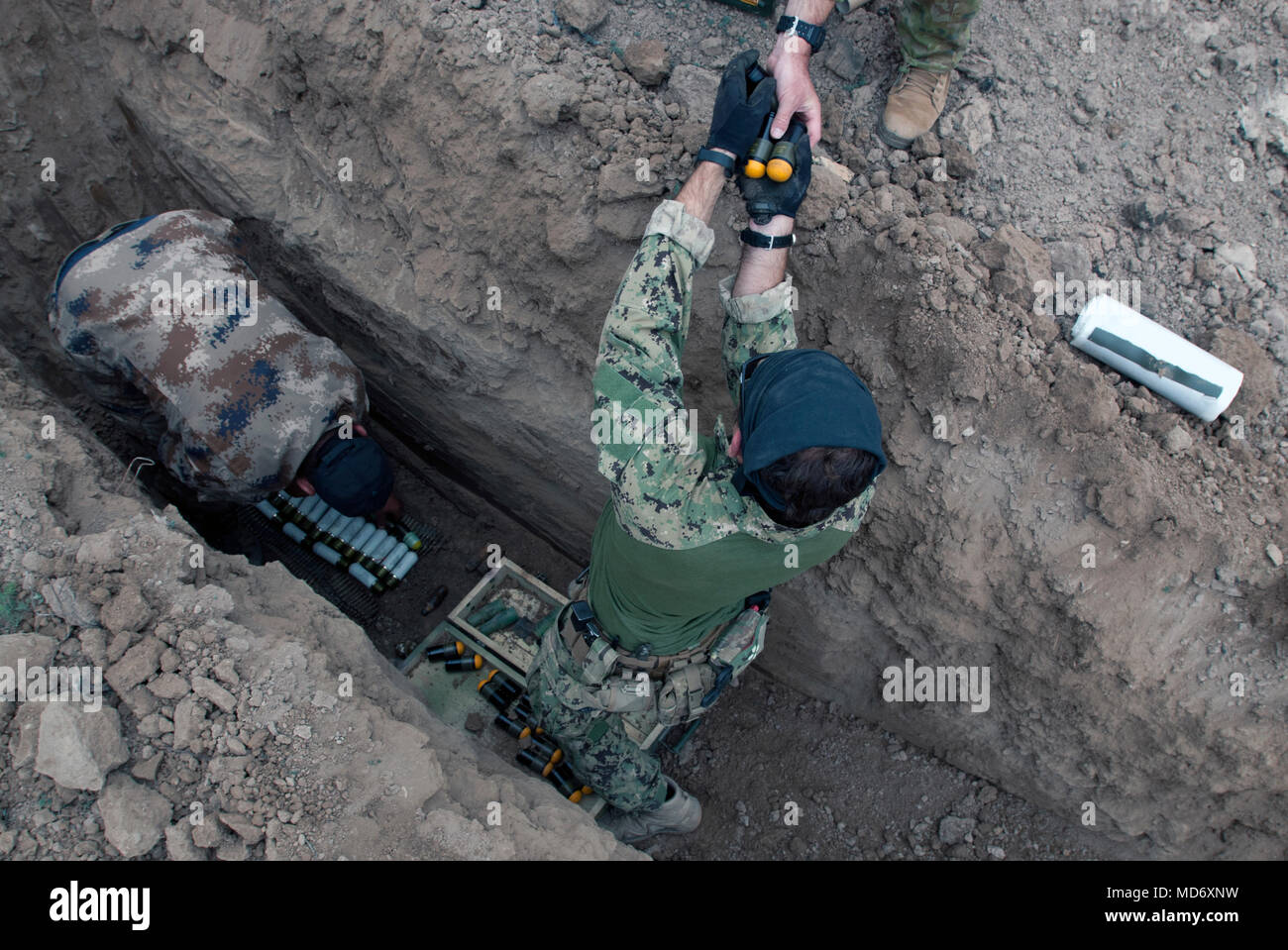Coalition trainers bury explosives seized from an ISIS cache during a ...