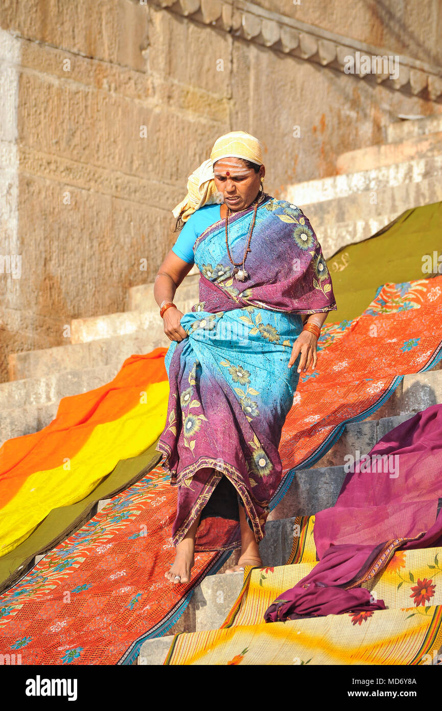 Dhobi woman descending ghat stairs between freshly laundered sarees ...