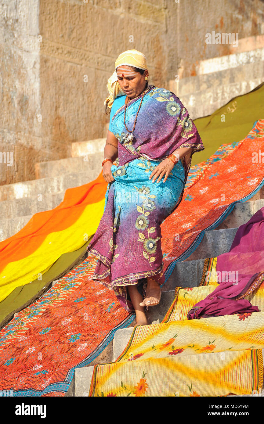 Dhobi woman descending ghat stairs between freshly laundered sarees ...