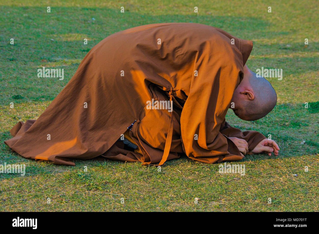 A Buddhist monk prays in the grounds of Dhamek Stupa at Sarnath Stock ...