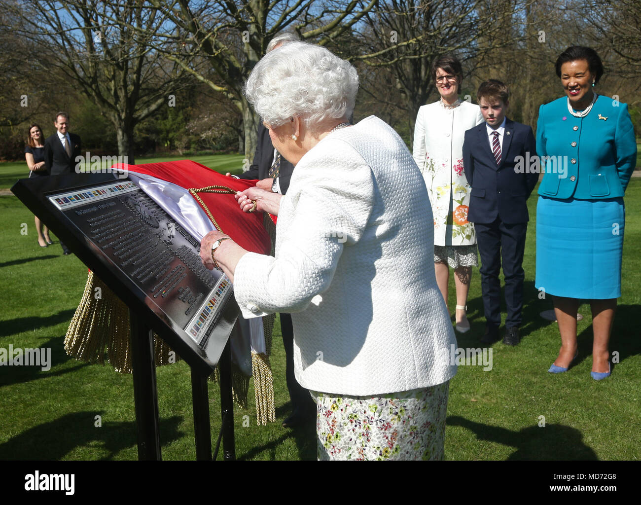 Queen Elizabeth II unveils a panel marking the walkway in Buckingham ...