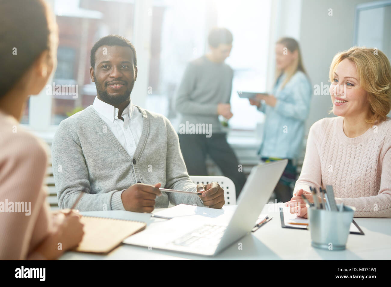 Multi-ethnic team of talented designers gathered together at spacious ...