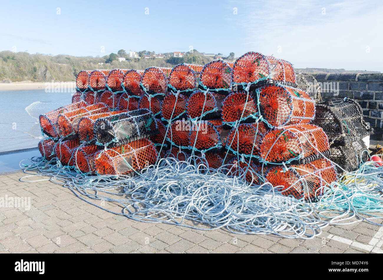 Fishermen's crab and lobster pots piled up on the quay at Tenby Harbour ...
