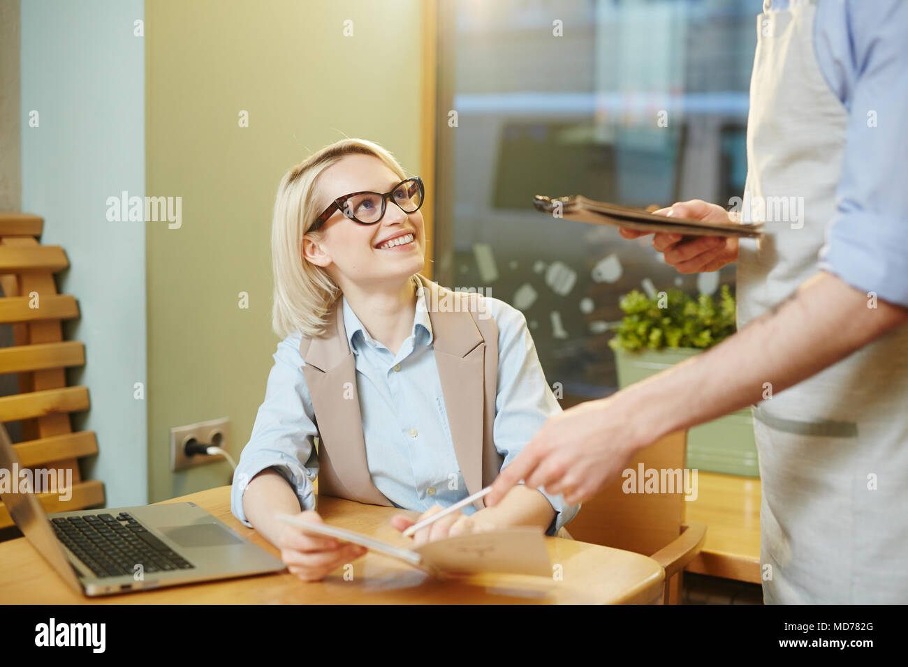 Businesswoman asking an advice from waiter about menu Stock Photo - Alamy