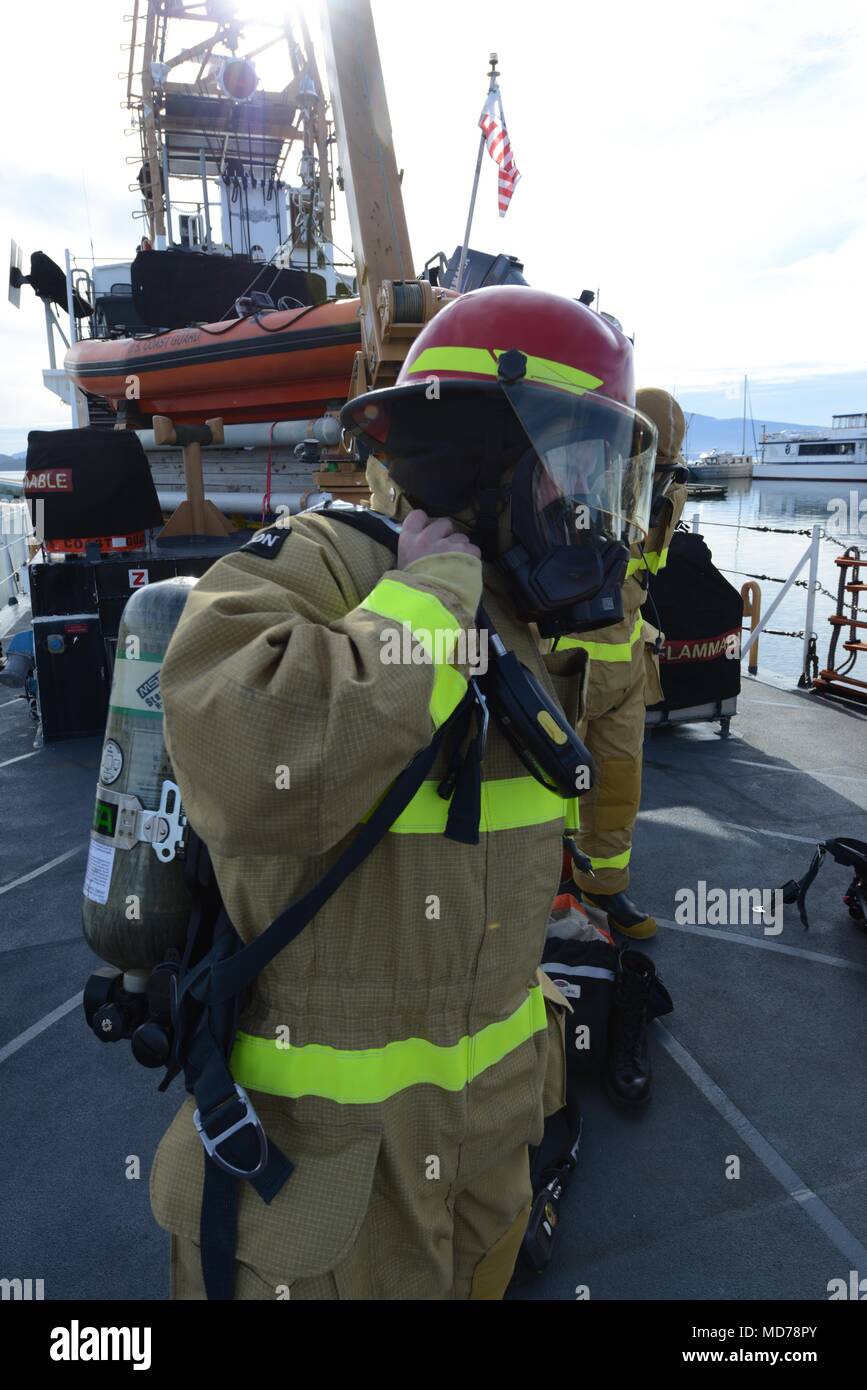 Petty Officer 3rd Class Blake Abraham dons fire fighting turnout gear ...