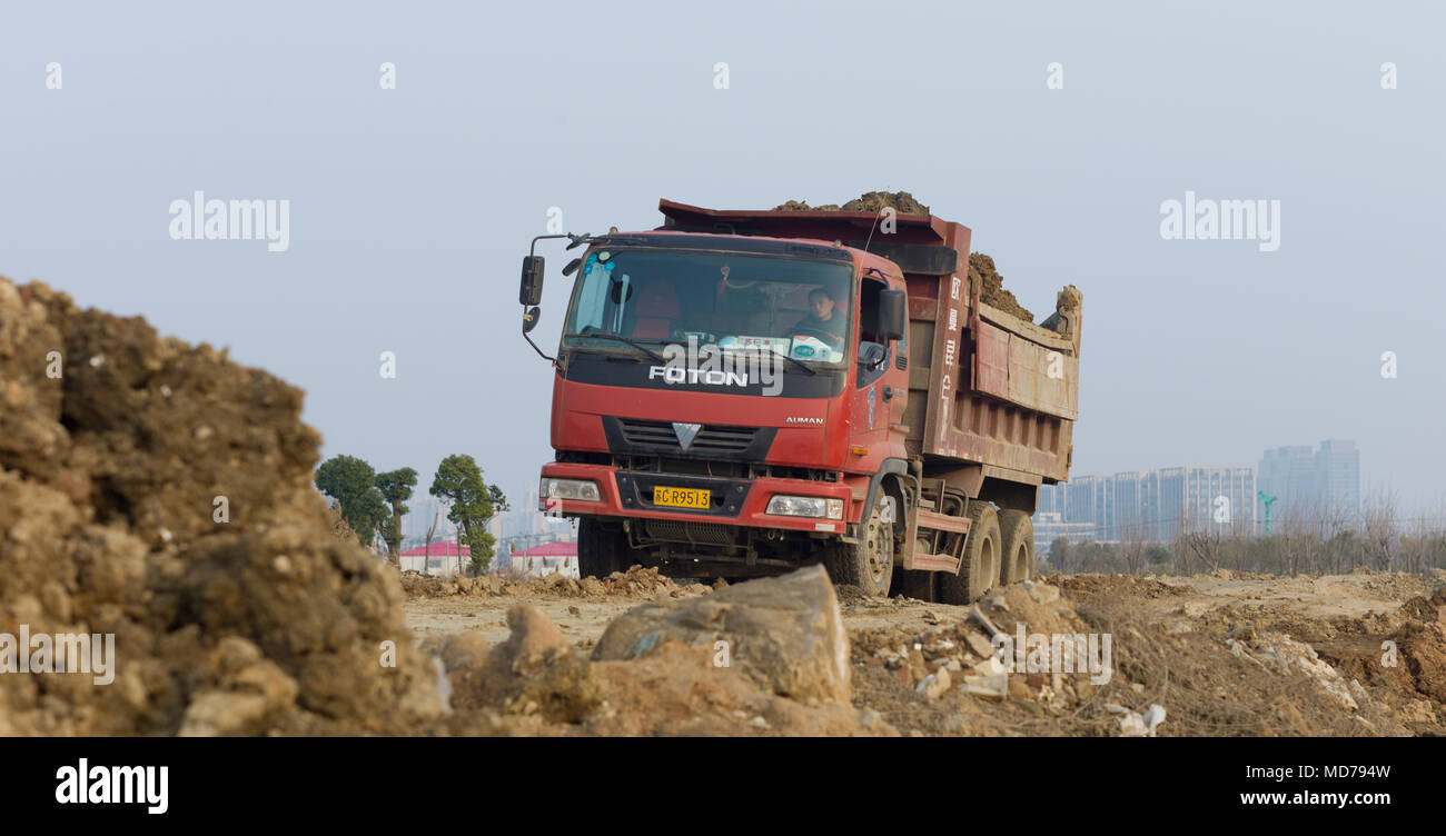 Earth-moving truck on construction site loaded with earth spoil, with ...