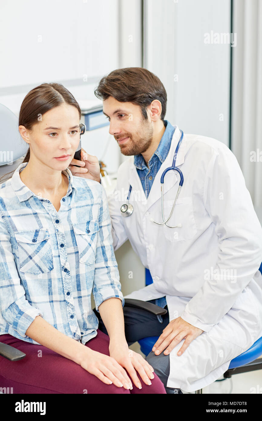 Doctor examining female patients ear with otoscope in clinic Stock ...