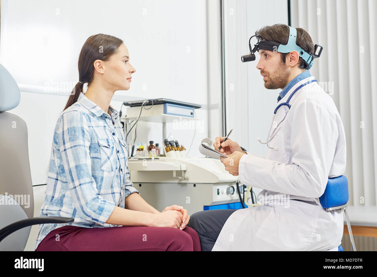 Doctor writing a prescription to his patient at hospital Stock Photo ...