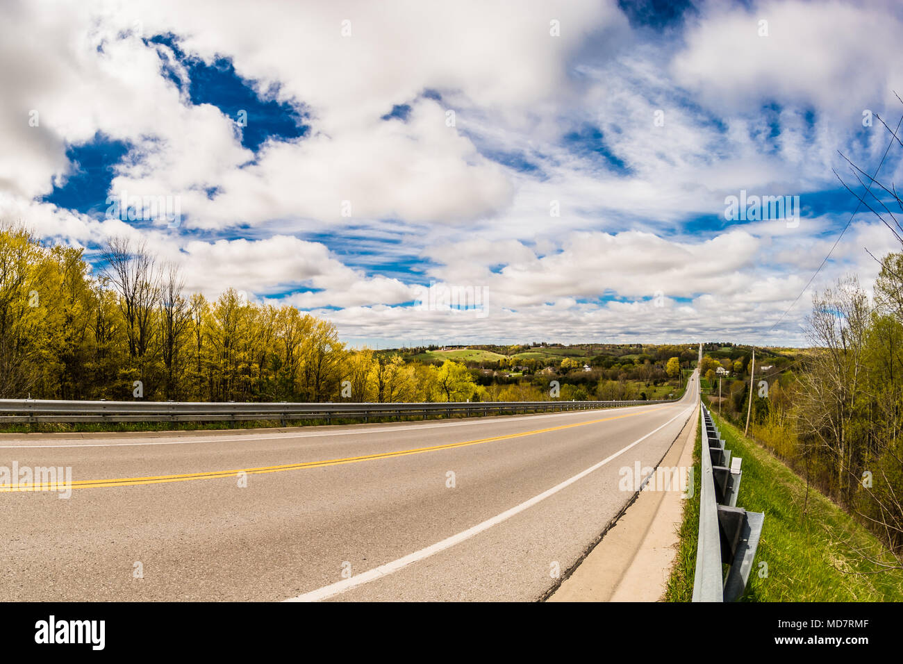 Open Road in Rural Area showing long paved road with beautiful blue sky ...