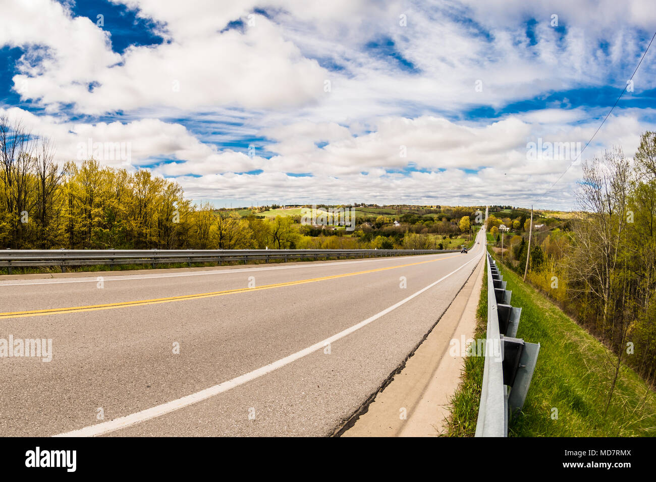 Open Road in Rural Area showing long paved road with beautiful blue sky ...
