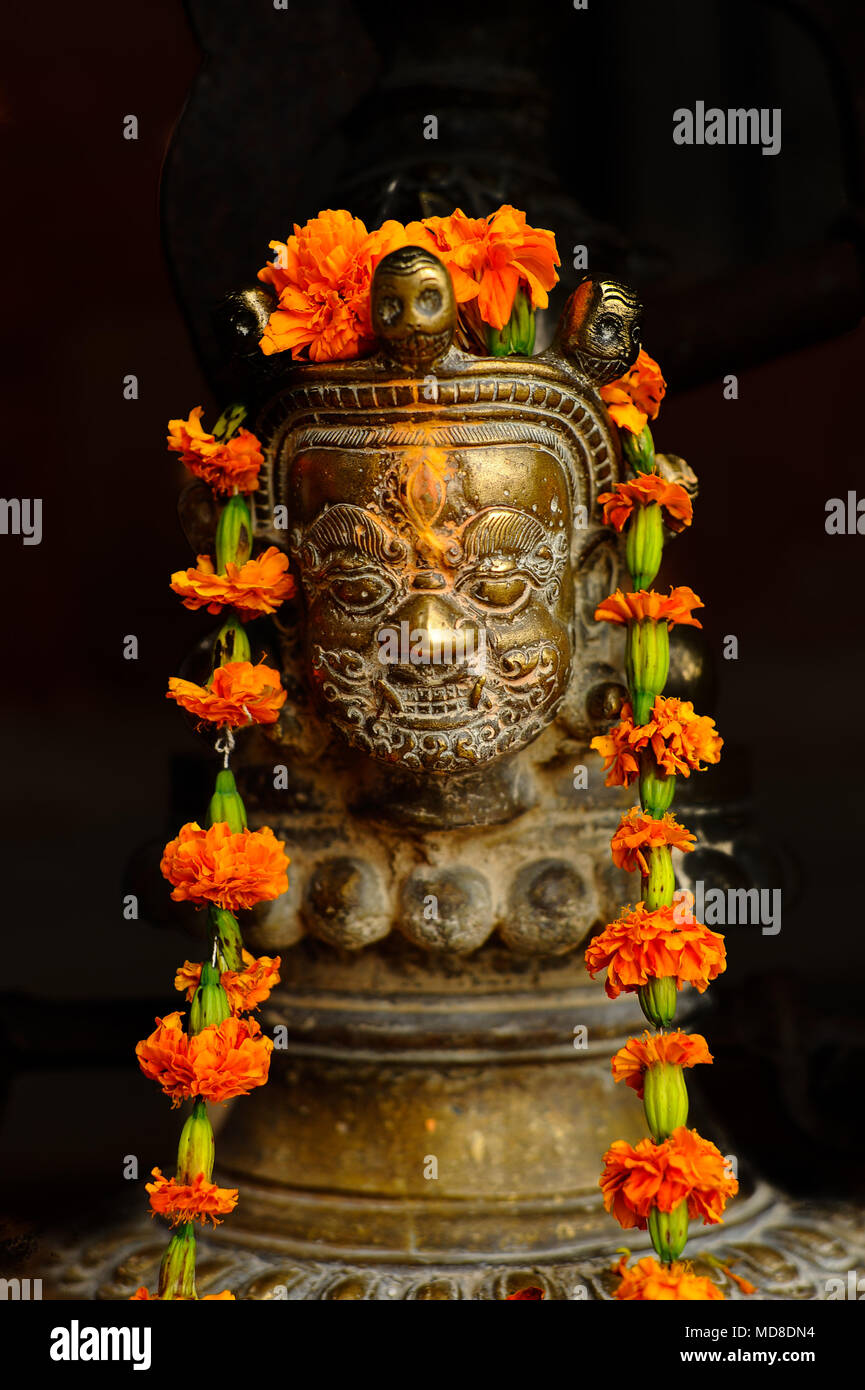Bell handle depicting Hindu deity enshrined with marigold garland Stock ...