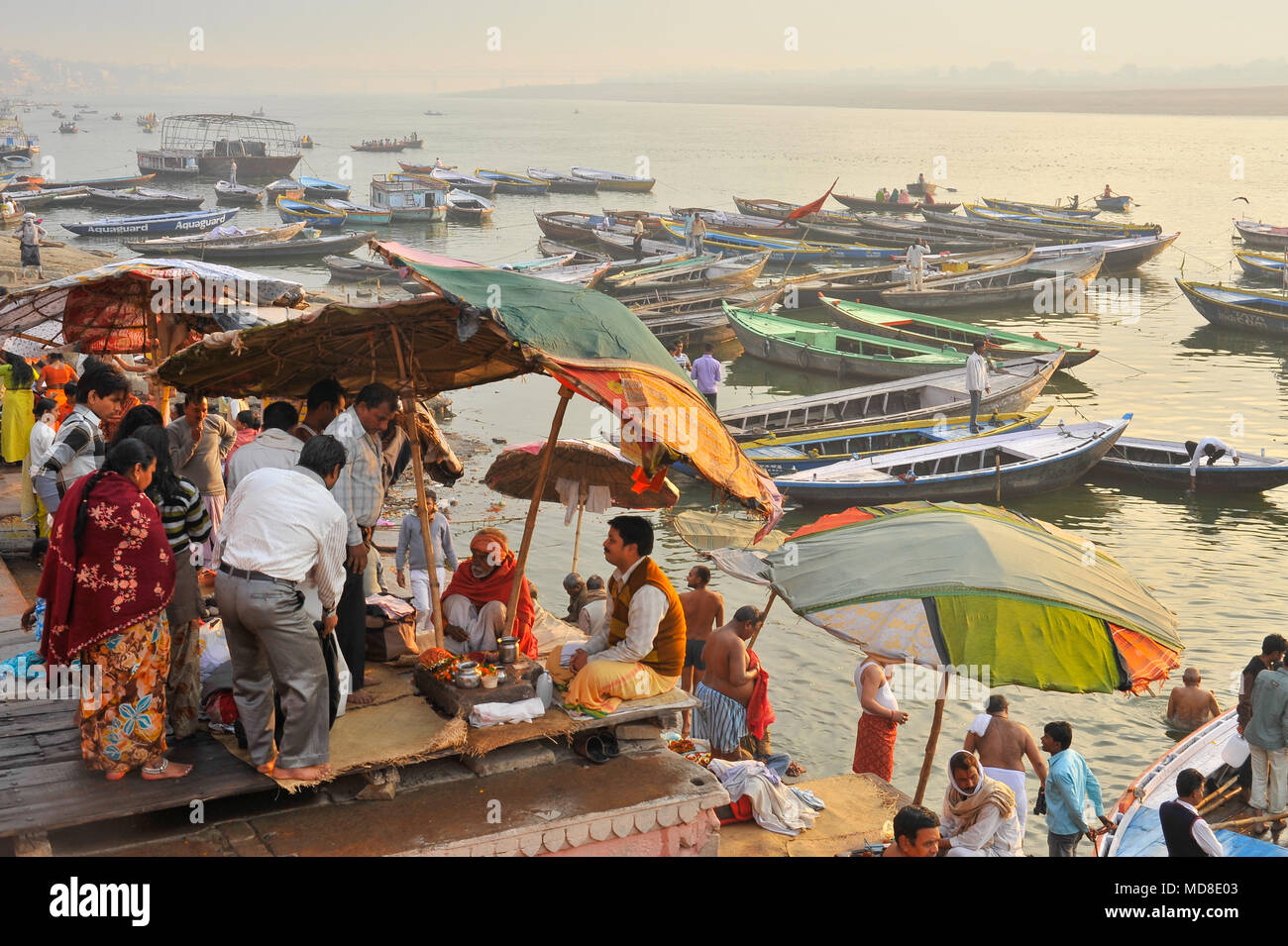 Hindu pilgrims receive blessing from a priest under a parasol by the ...