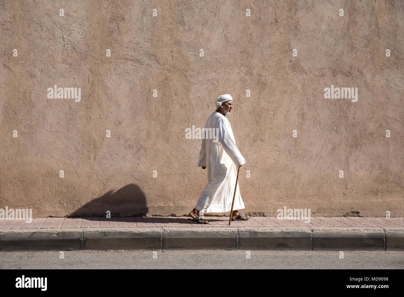 Nizwa, Oman - Mar 23, 2018: An elderly Omani man with a wooden cane ...