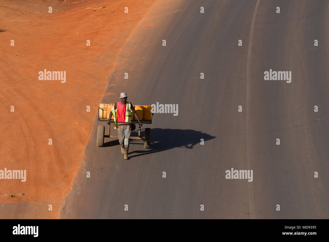 Man pulling a handcart which is know as a 'mkokoteni' Swahili, loaded ...