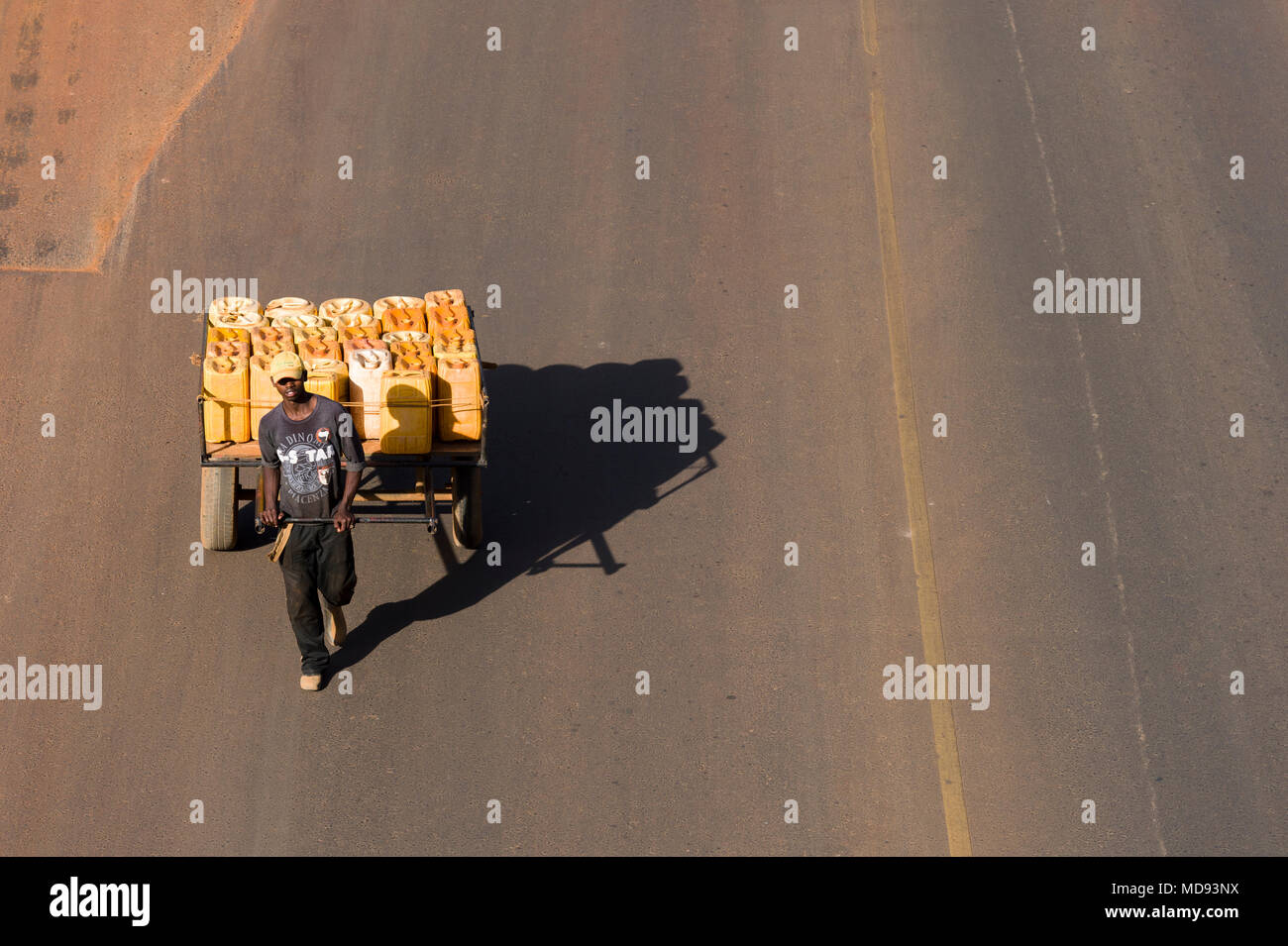 Man pulling a handcart which is know as a 'mkokoteni' Swahili, loaded ...