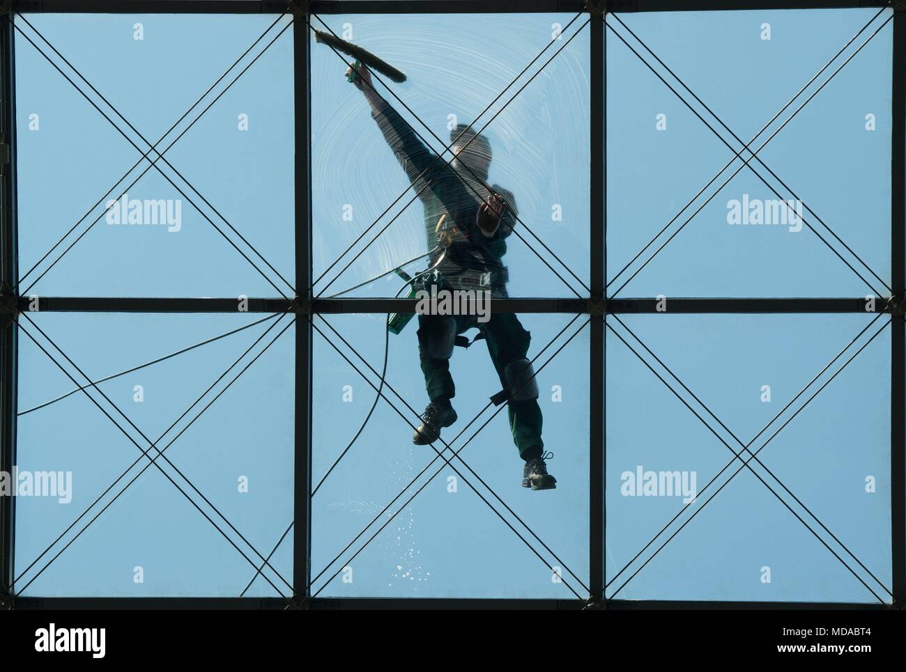 19 April 2018, Germany, Dresden: A building cleaner cleaning the glass ...