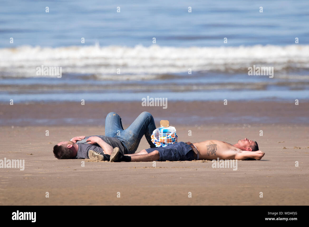 Two men sunbathing on beach hi-res stock photography and images - Alamy