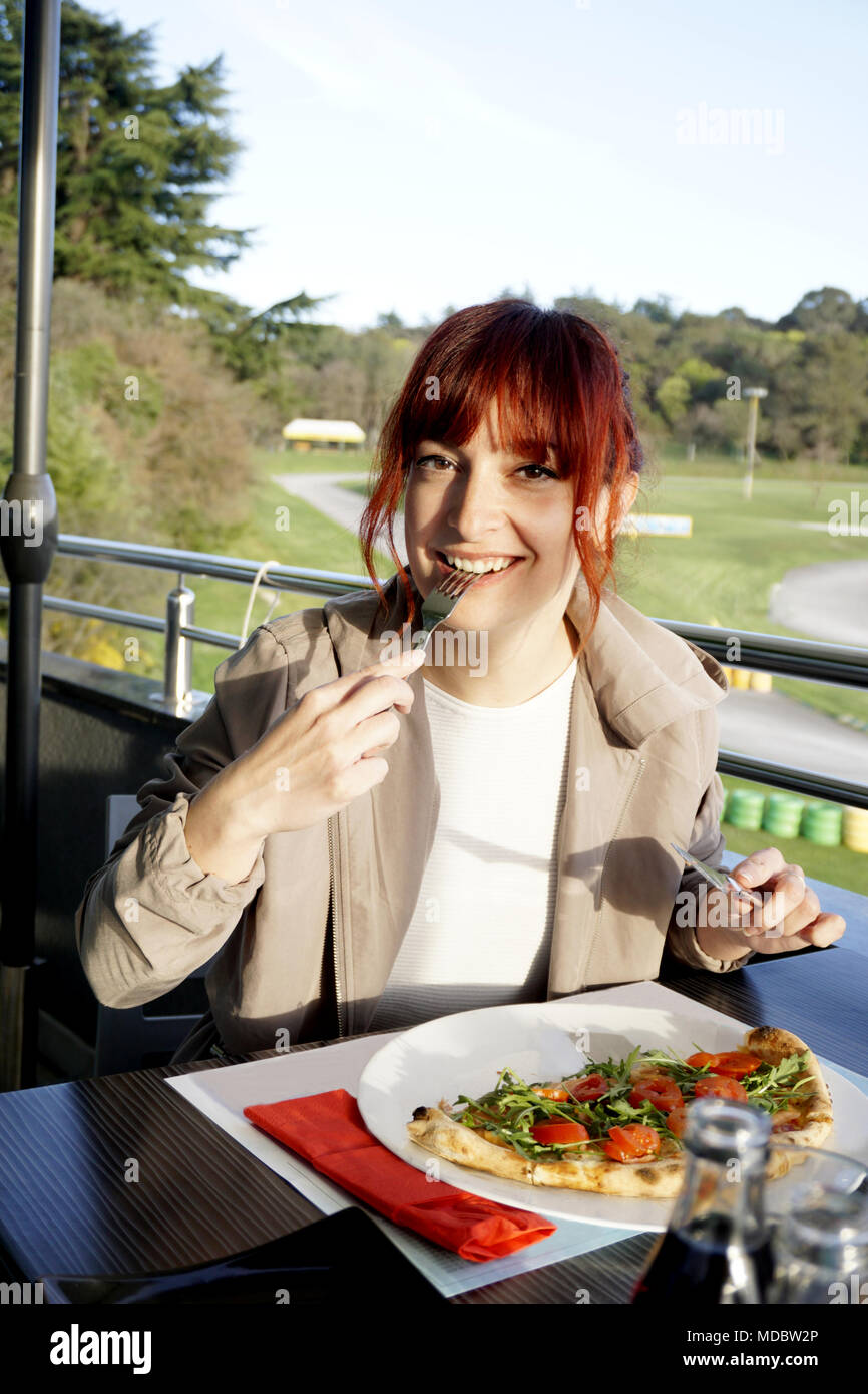 Beautiful young woman eating a pizza in the restaurant. Portrait of a ...