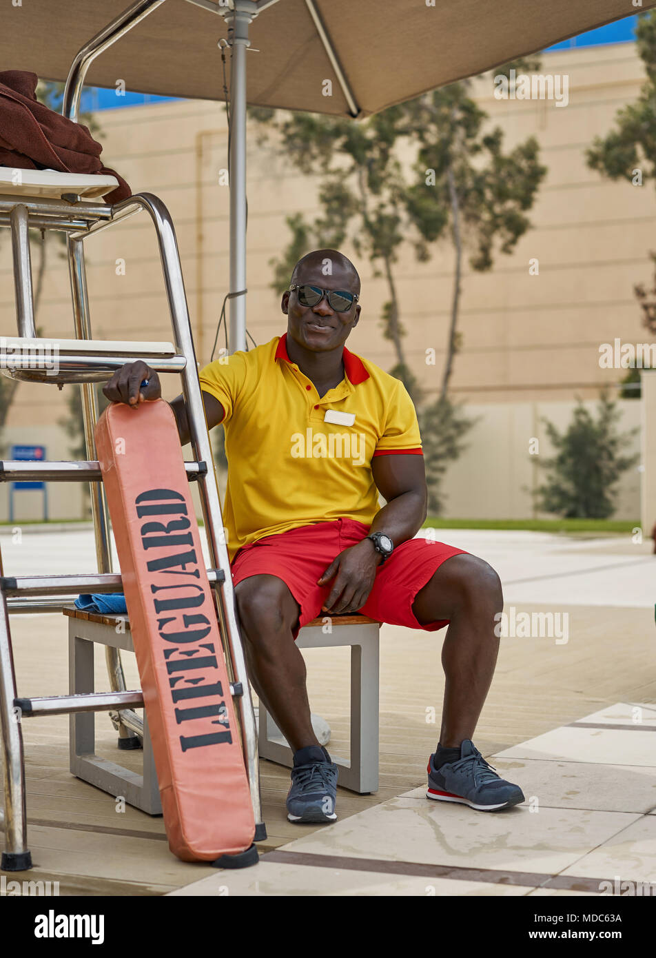 black lifeguard sitting by the pool Stock Photo - Alamy