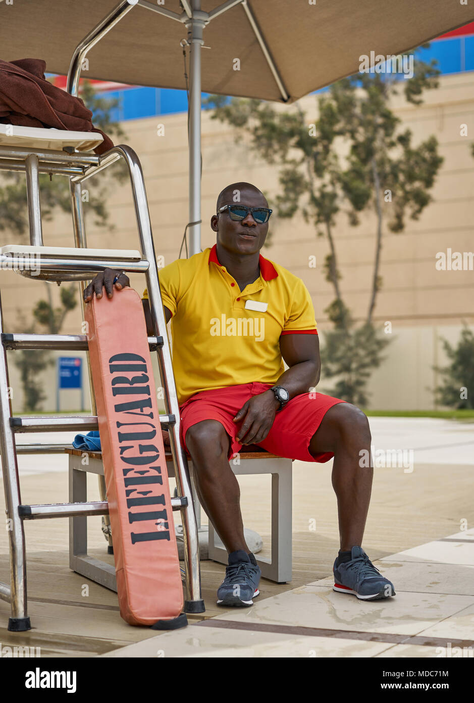 black lifeguard sitting by the pool Stock Photo - Alamy