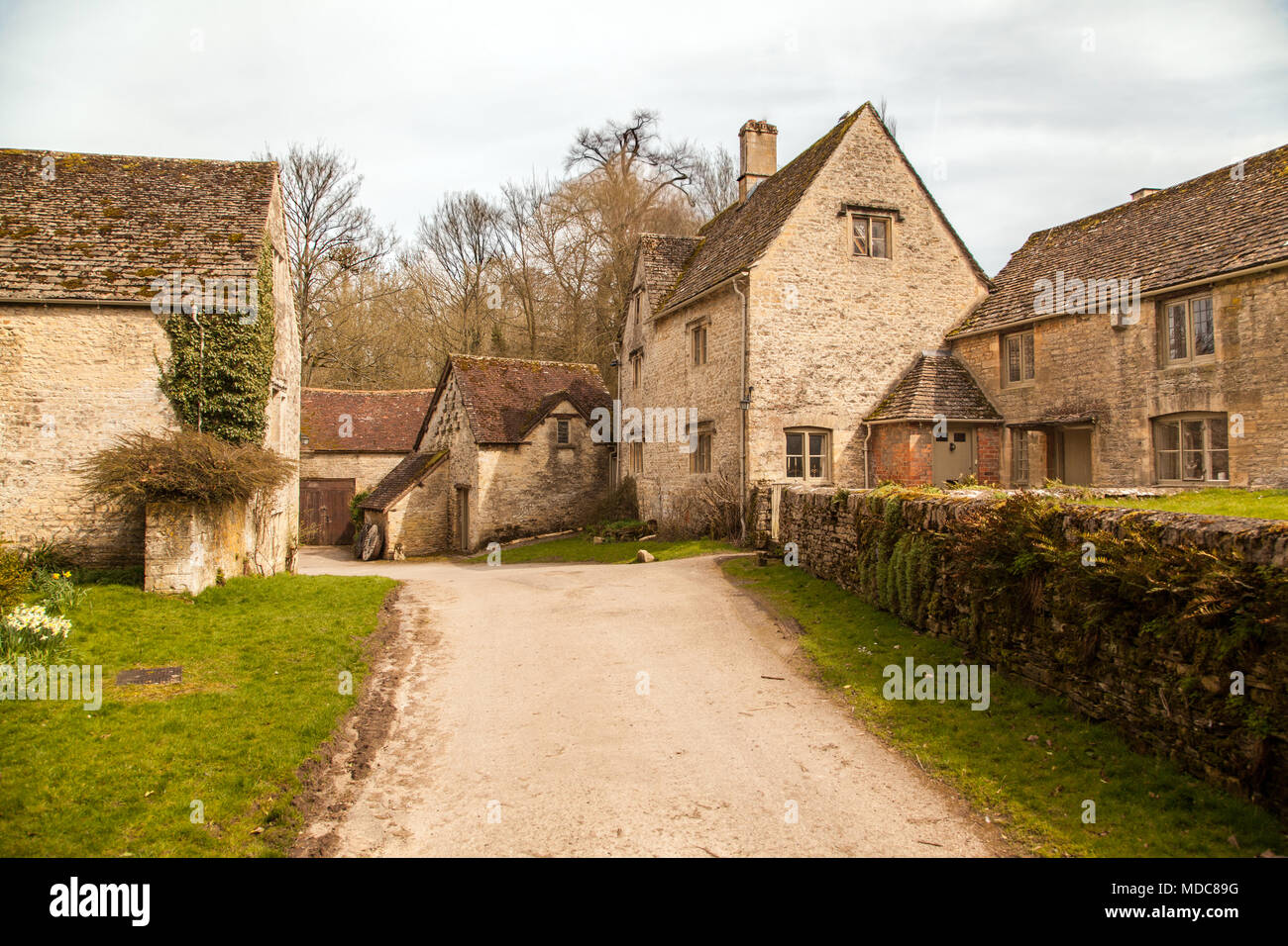 Traditional Cotswold's stone farmhouse with country lane winding ...