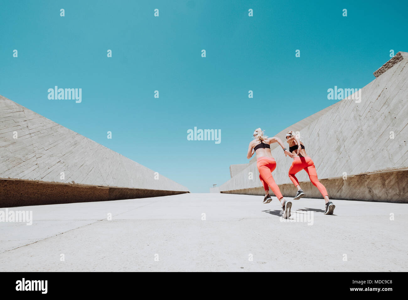 Two female runners running side by side Stock Photo - Alamy