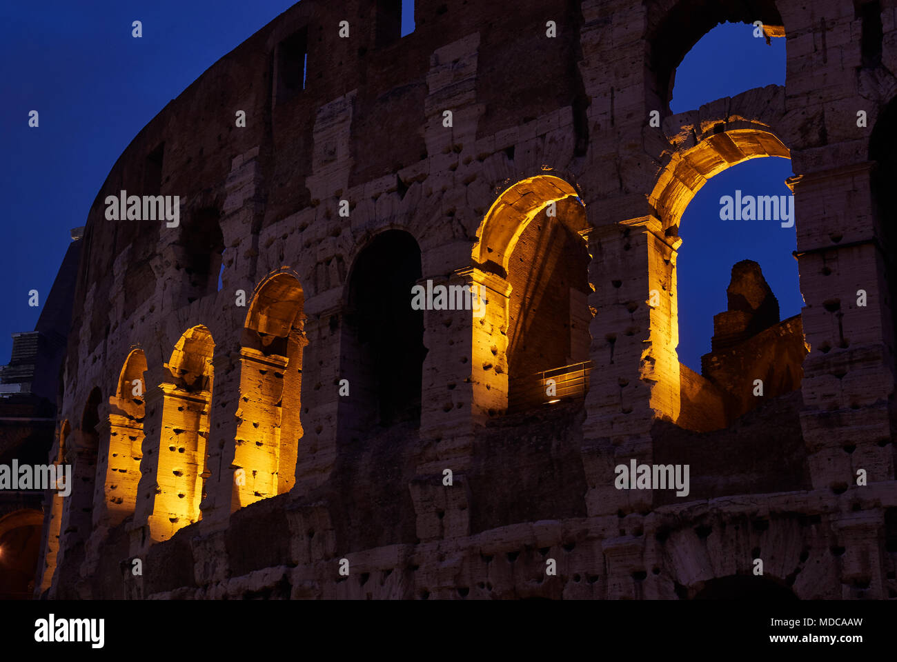 The illuminated arches of the Coliseum, just before sunrise. Rome ...