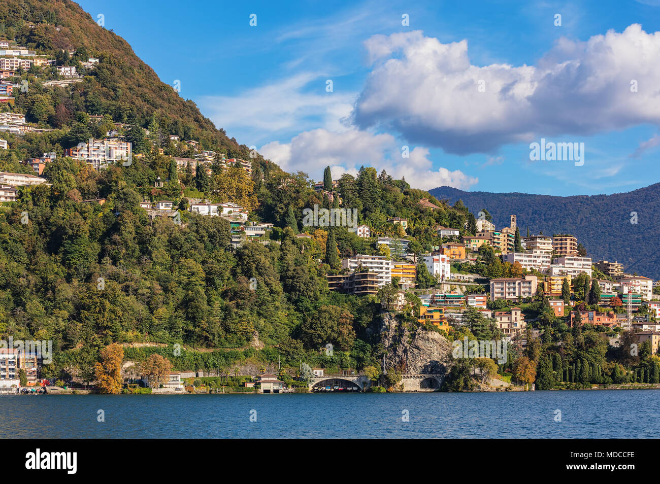 Buildings on the foot of the Monte Bre mountain in Switzerland, view ...