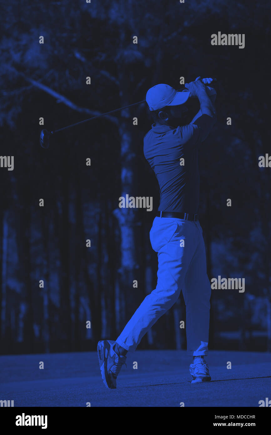 golf player hitting shot with driver on course at beautiful sunny day ...