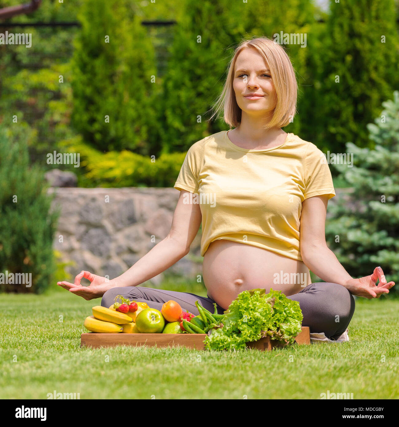 Pregnant woman practicing meditation and relaxation in nature Stock ...