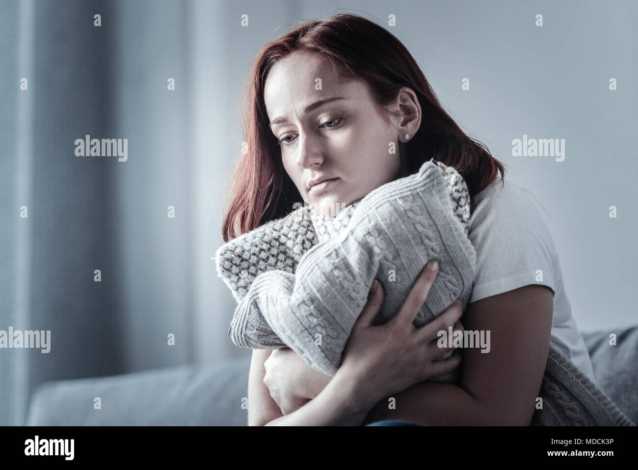 Sad beautiful woman hugging pillow Stock Photo - Alamy