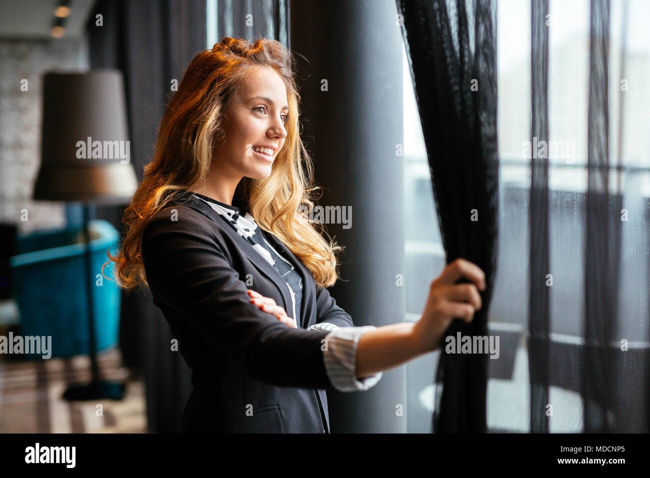 Glamorous woman staring through window Stock Photo - Alamy