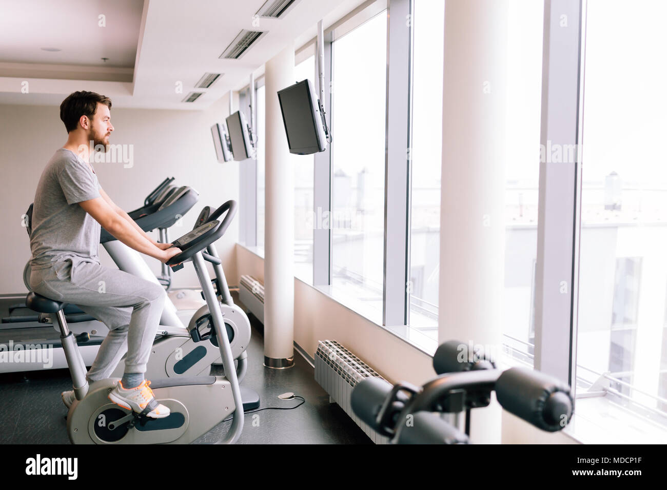 Male training on exercise bicycle hi-res stock photography and images ...