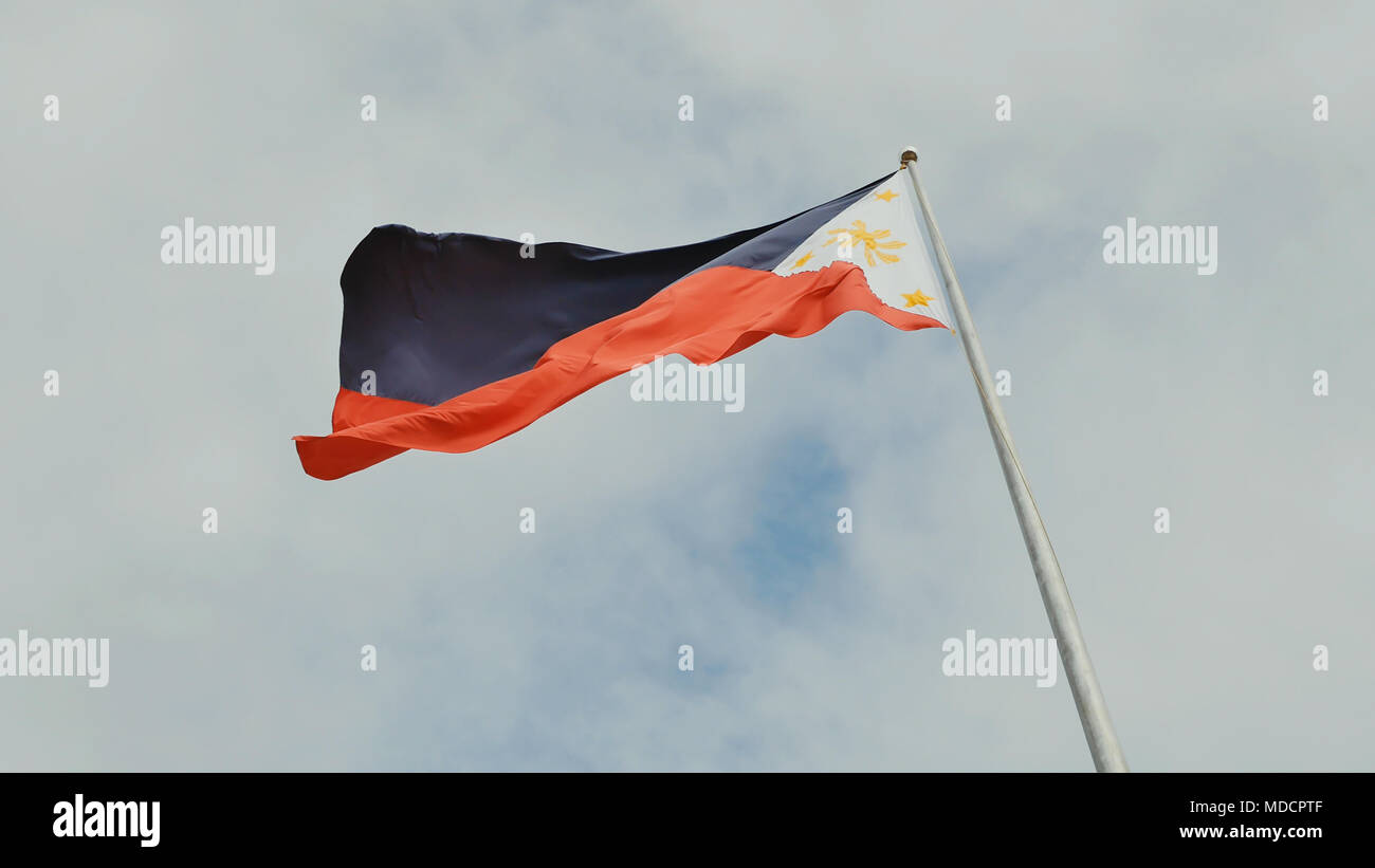 Flying bicolor flag of the Philippines with central golden sun ...