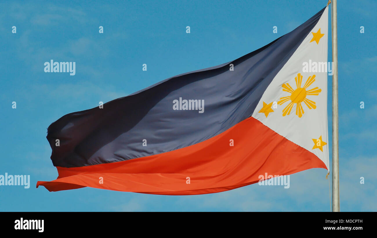 Flying bicolor flag of the Philippines with central golden sun ...