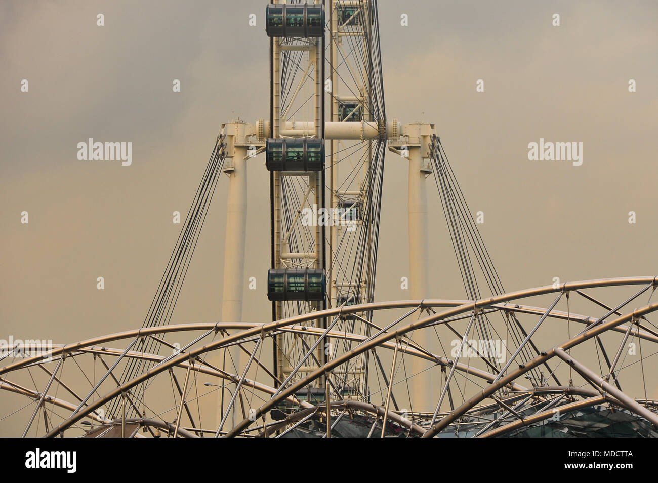 Section of ferris wheel viewed through bridge structure, Singapore ...