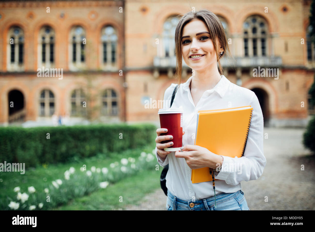 Happy smiling student girl with backpack at university background ...