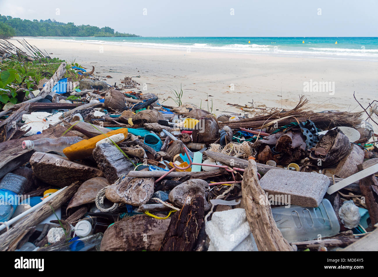 Pollution on the beach of tropical sea. Plastic garbage, foam, wood and ...