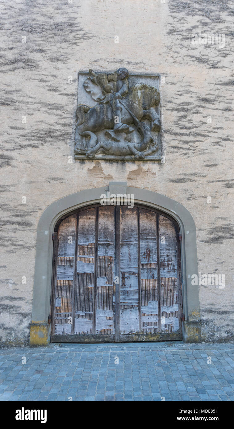 old handmade medieval wooden gate with a commemorative town seal above ...