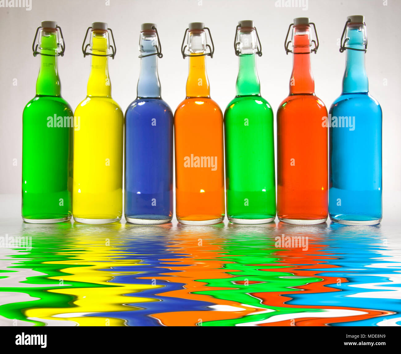 Colorful bottles reflected in water Stock Photo - Alamy