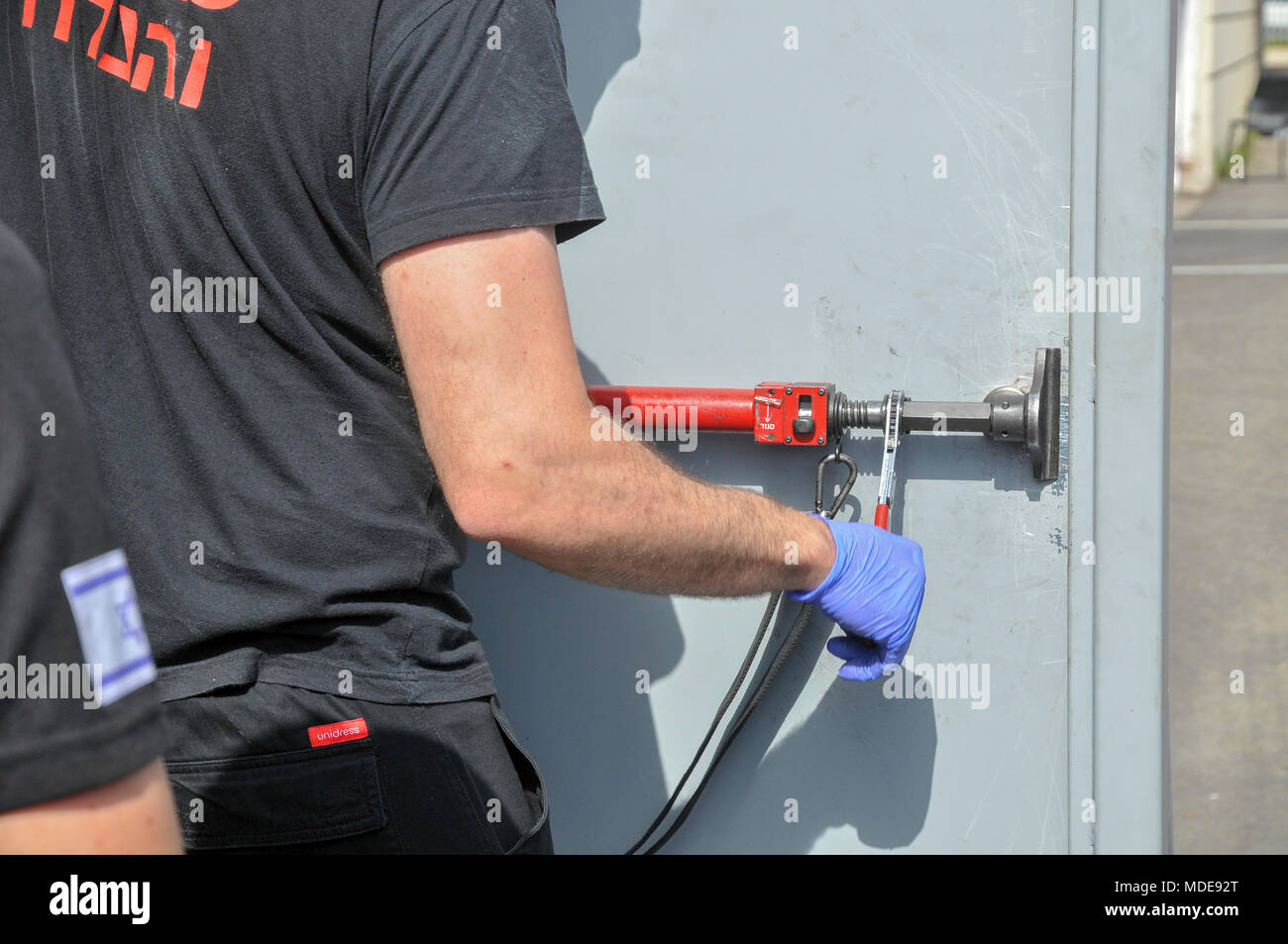 Fire fighter uses hydraulic tools to breach a locked door Stock Photo ...