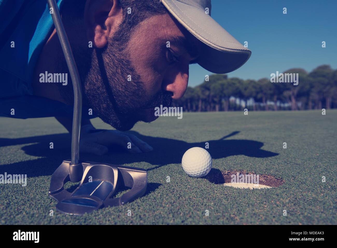 golf player blowing ball in hole. concept of cheating and success Stock ...