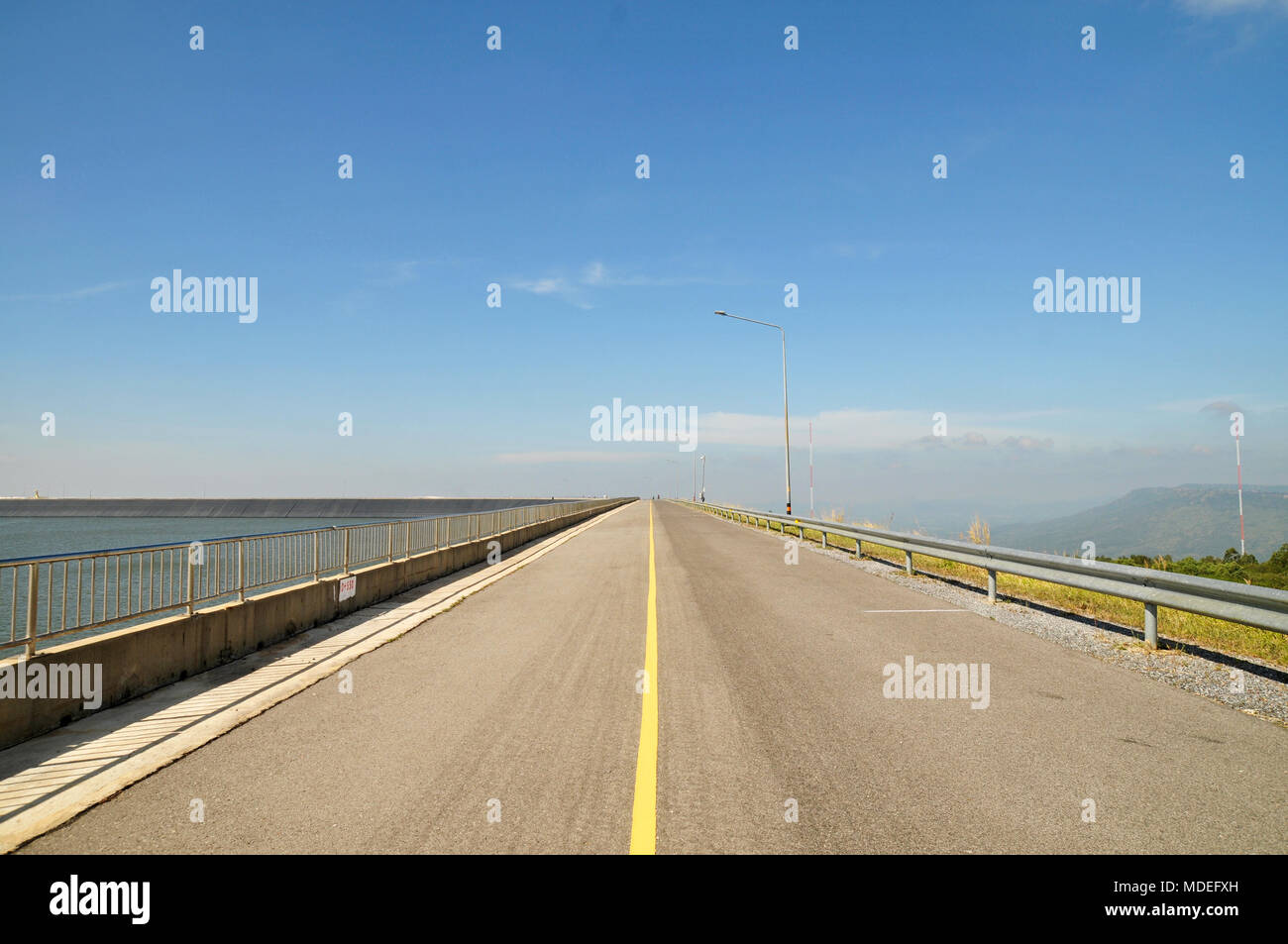 Long and empty straight road running to nowhere with blue sky ...
