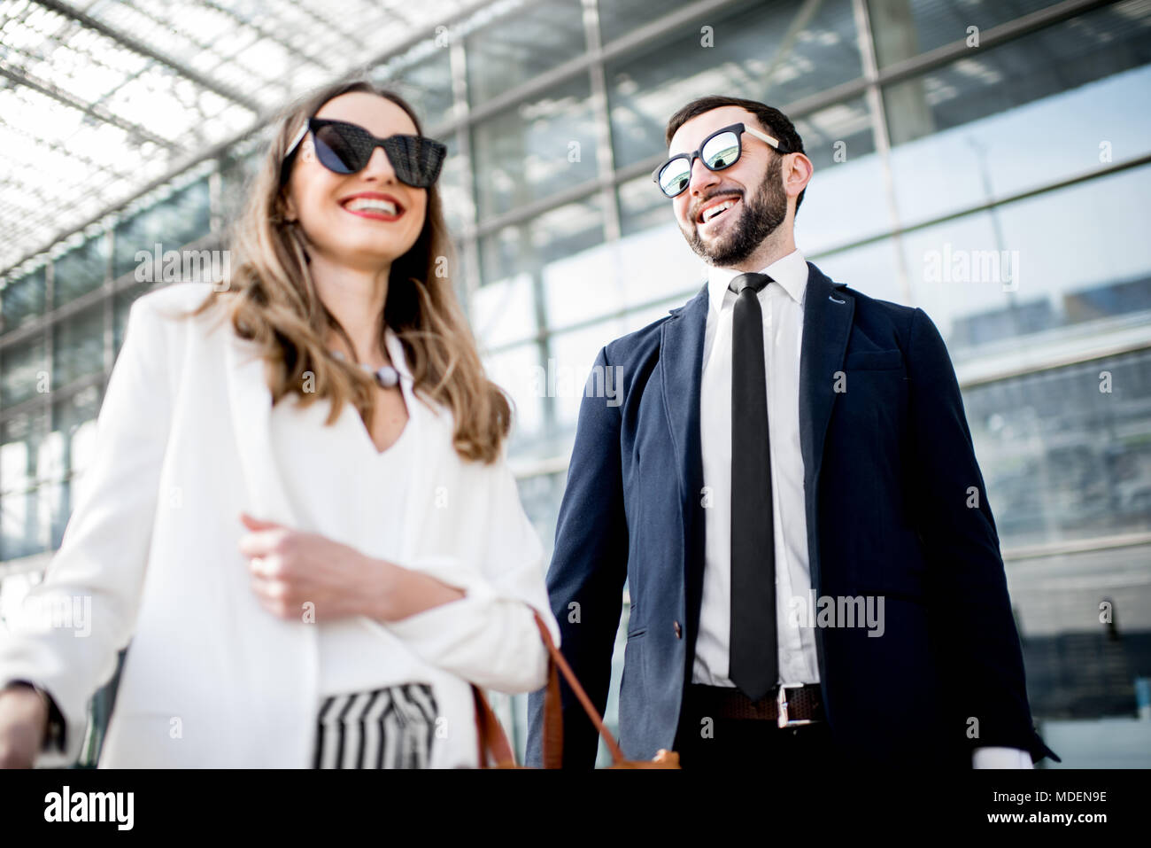 Business woman and man in suits standing near the modern building ...