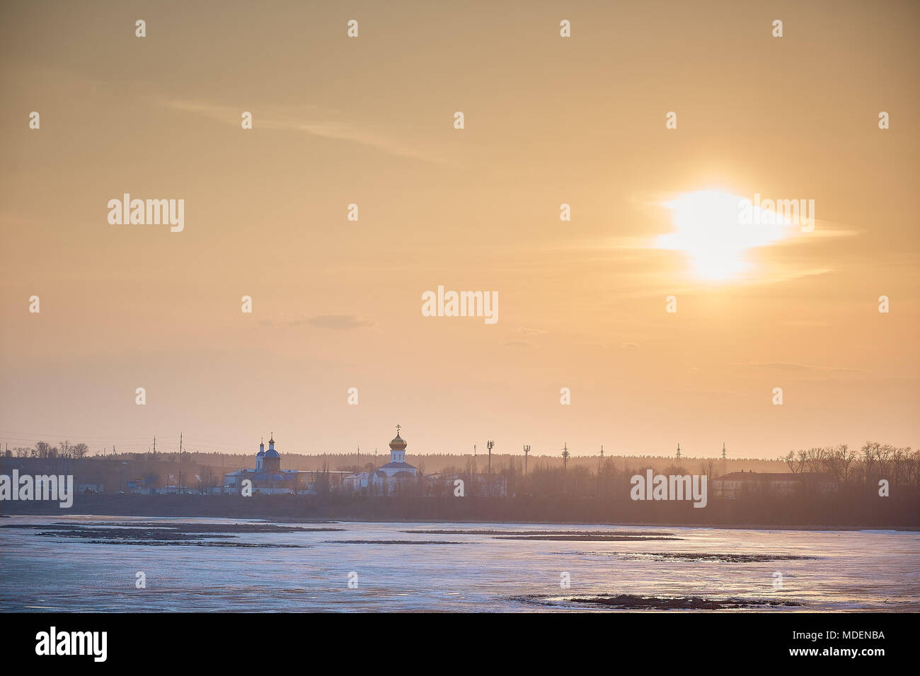 sunset over the Orthodox monastery. Russian city in the spring, ice on ...