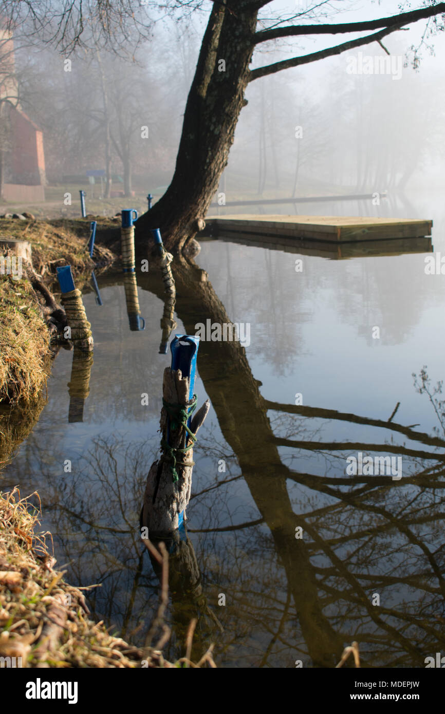 Boat securing posts in water Stock Photo - Alamy