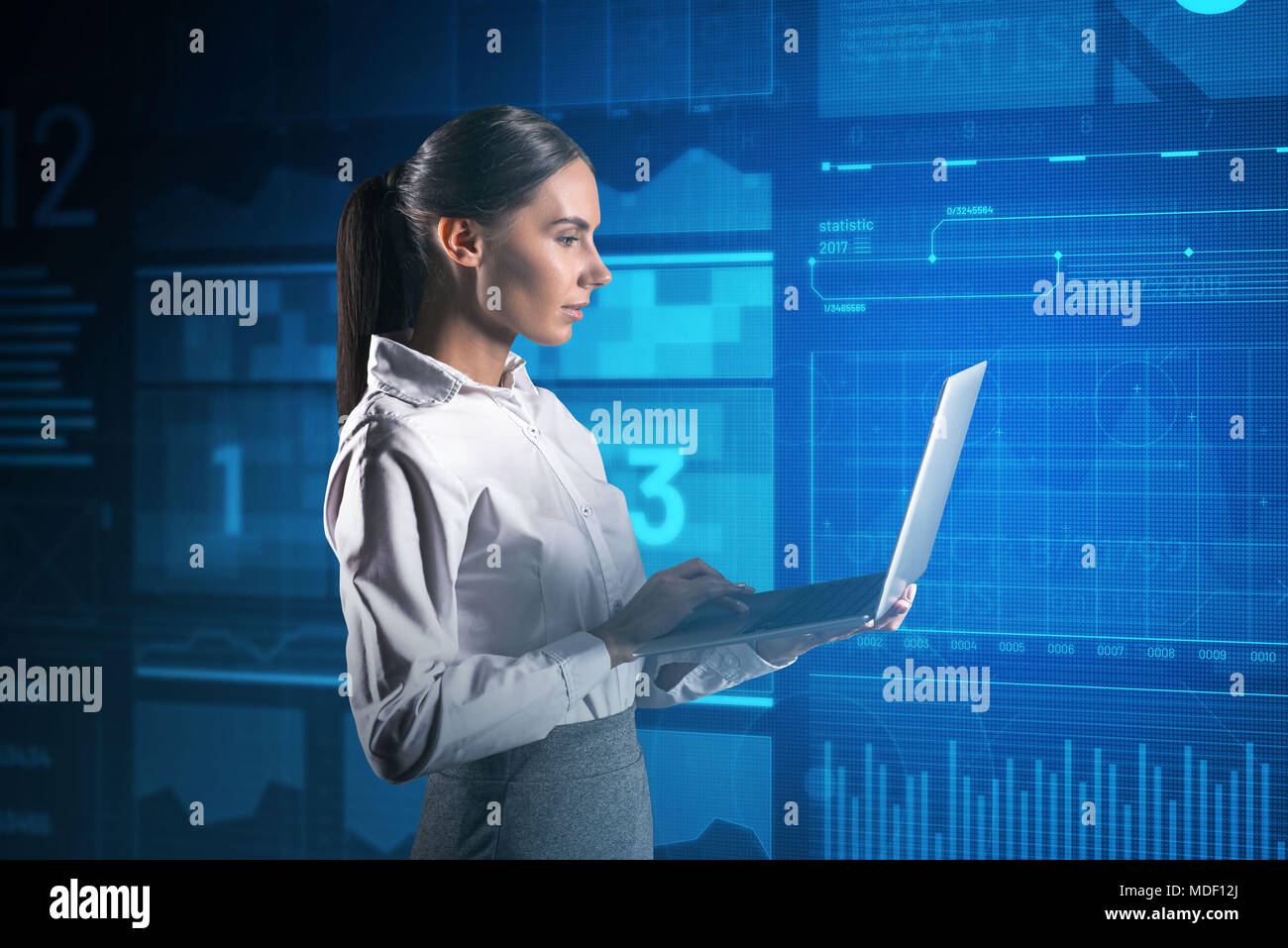 Smart programmer holding a modern laptop and looking at the screen ...