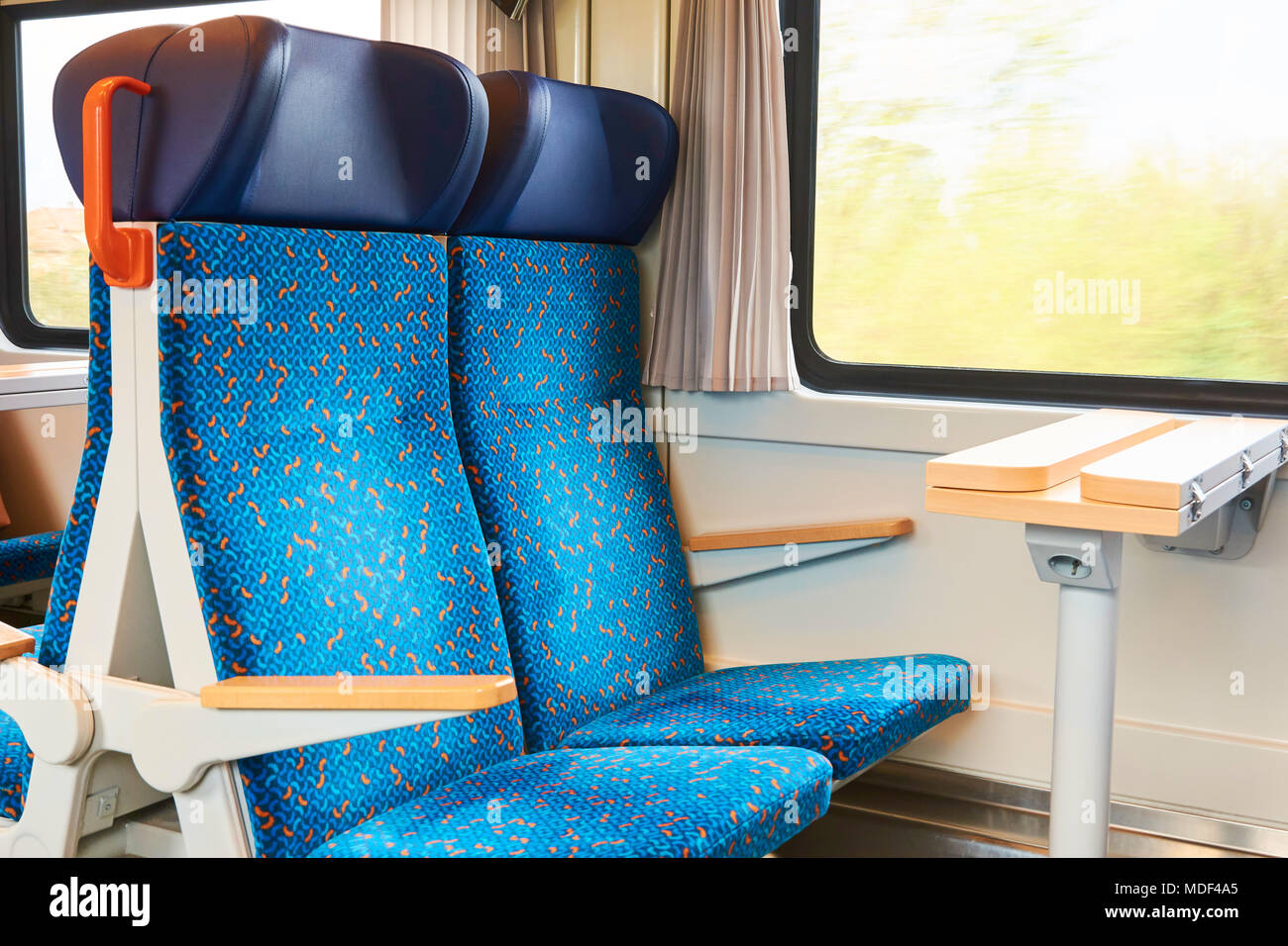 Two blue seats and a desk with an electric drawer in the interior of a ...