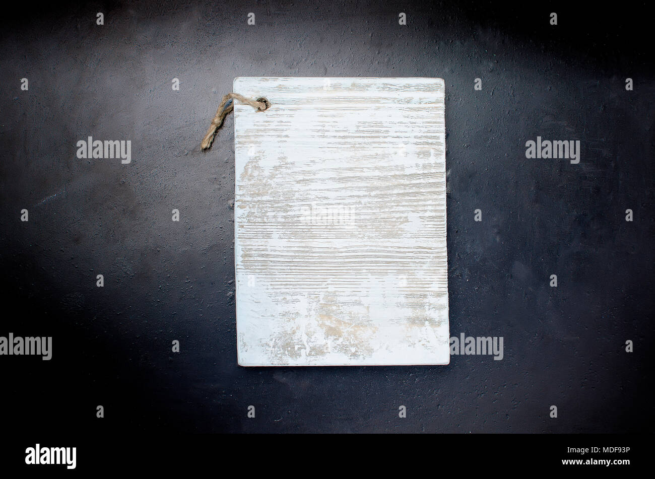 white kitchen cutting board of rectangular shape with a rope lies on a ...
